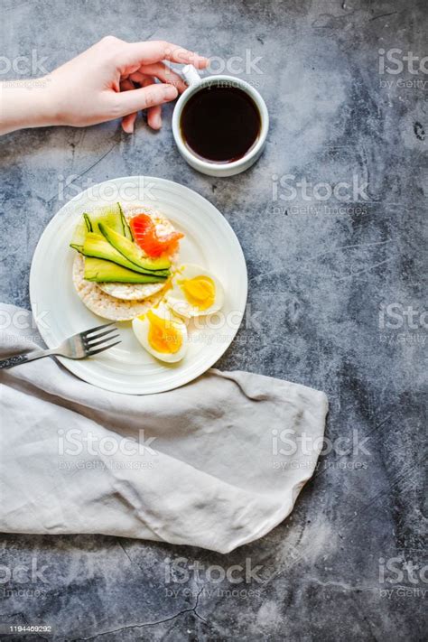 아보카도와 신선한 소금에 절인 연어 필레와 회색 대리석 배경에 계란쌀 바삭한 케이크 맨 위 보기 텍스트의 공백입니다 고단백 및