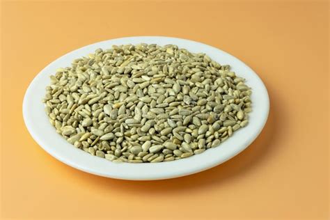 View Of Unshelled Sunflower Seeds In A Plate On An Orange Background