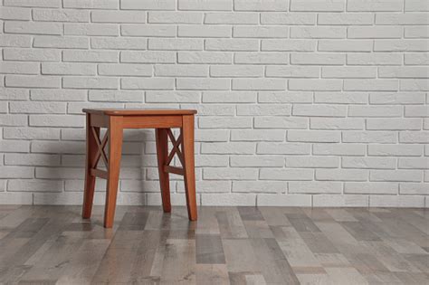 실내의 흰색 벽돌 벽 근처에 세련된 나무 대변 텍스트 공간 0명에 대한 스톡 사진 및 기타 이미지 0명 가구 디자인