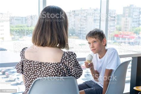 귀여운 행복한 어린 소년 소년이 창문을 향해 카페의 테이블에 앉아있는 어머니와 이야기하고 있습니다 엄마가 아들에게 말하다 2명에 대한 스톡 사진 및 기타 이미지 Istock