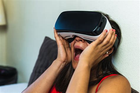 Scared Brunette Woman With Her Mouth Open And Holding Her Hands To Her