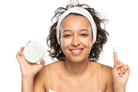 하얀 배경에 고립된 젊은 인도 여성 하얀 셔츠가 크림에 담근 손가락을 들고 카메라에 포즈를 취하며 즐겁게 웃고 있다 20 24세에 대한 스톡 사진 및 기타 이미지 Istock