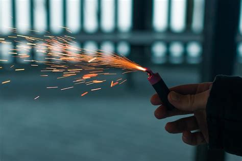 Premium Photo Burning Firecracker With Sparks Guy Holding A Petard In