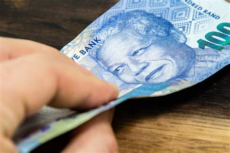 백인 손을 들고 나무 테이블 위에 백 남아 프리 카 공화국 랜드 참고 이 이미지는 지불을 나타내는 데 사용할 수 있습니다 남아프리카 공화국 통화에 대한 스톡 사진 및 기타