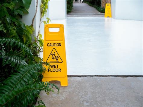 Premium Photo Yellow Caution Slippery Wet Floor Sign With Slippery Person Warning Icon On Wet