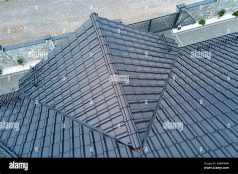 Closeup Of House Roof Top Covered With Shiny Ceramic Shingles Stock