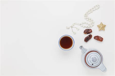 테이블 장식 라마단 카림 휴일 백그라운드의 상위 뷰 공중 이미지 화이트 묵 주 및 컵 차 평면 위치 날짜 할랄 식사 금식에 대