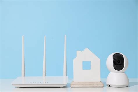 Premium Photo Wooden House Router And Security Camera On Blue Background