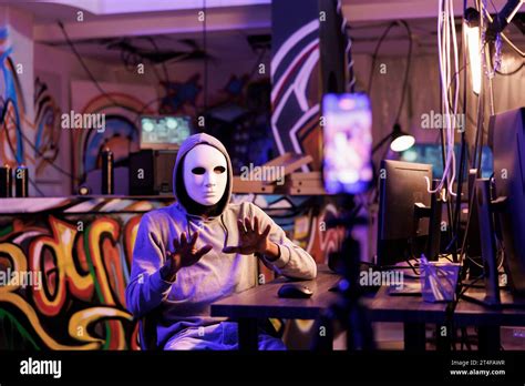 Hacker In Anonymous Mask Live Streaming Illegal Content Online On Mobile Phone Criminal