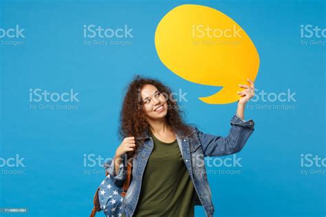 데님 옷 배낭 홀드에 젊은 아프리카계 미국인 소녀 십 대 학생 파란색 배경 스튜디오 초상화에 고립 된 구름을 말한다 고등학교 대학 대학 개념에서 교육 복사 공간을 모의