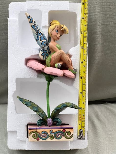 Tinkerbell Sitting On Flowers Tattoos