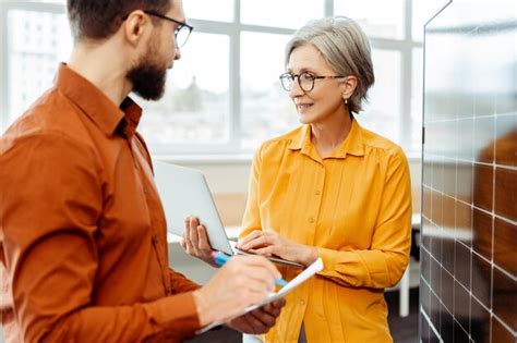 Premium Photo Smiling Engineers Man And Senior Woman Planning Startup Using Laptop Solar Panel