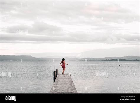 Jeunes Filles Caucasiennes Dansant En Portant Une Robe Rose Avec Des Sandales Sur Un Lac Calme