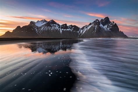 Pôr do sol na montanha vestrahorn e na praia de stokksnes vestrahorn é
