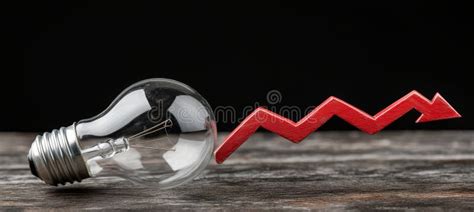 Light Bulb And Red Up Arrow On Wooden Plank Black Background Concept