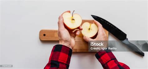 남성의 손에 사과의 두 반쪽이 높은 각도로 보입니다 남자는 칼로 사과를 자릅니다 건강한 생활방식에 대한 스톡 사진 및 기타 이미지 건강한 생활방식 건강한 식생활 과일