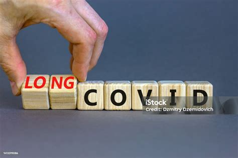 긴 코비드 기호 닥터는 나무 큐브를 돌리고 단어 코비드를 긴 코비드로 바꿉니다 아름다운 회색 테이블 회색 배경 복사 공간 의료