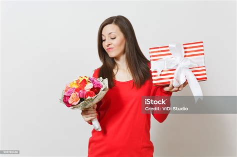 아름 다운 장미 꽃의 꽃다발을 들고 빨간 옷에 슬픈 화가 여자 흰색 배경에 고립 된 선물 상자를 제시 성 발렌타인의 날 국제