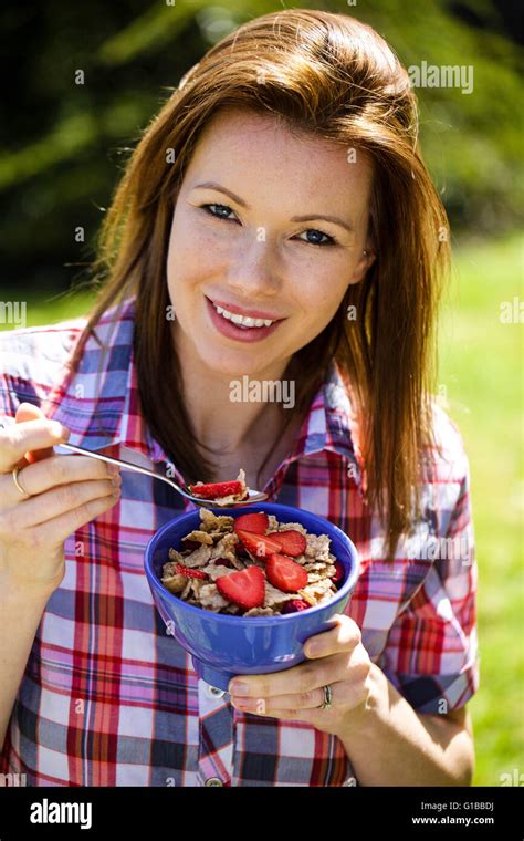 Portrait Of A Woman Outside Eating Healthy Breakfast Cereals With Fresh