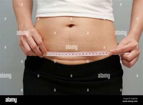 Woman Using Tape Measuring The C Section Scar Of Cesarean On Her Belly