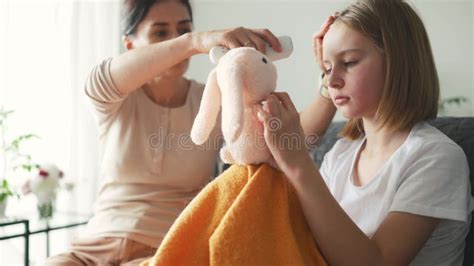 Caring Mother Is Measuring High Temperature To Her Sick Daughter Stock
