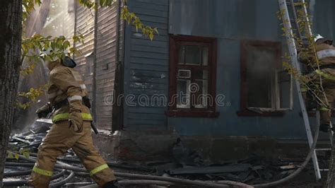 Firefighters Extinguish The Fire Burning Old Abandoned House Stock