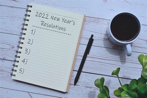 2022 나무 책상에 커피 펜 녹색 잎 배경한 잔이 있는 메모장에 2022 년 새해 결심 목록 0명에 대한 스톡 사진 및 기타