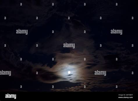 The Moon Half Hidden By Passing Cluds Lights Them From Behind Producing