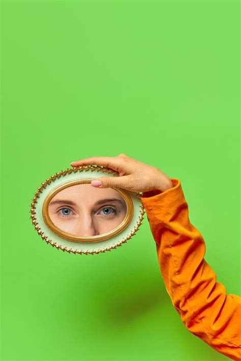 Female Hand Holding Small Mirror With Drawn Female Eye Over Green