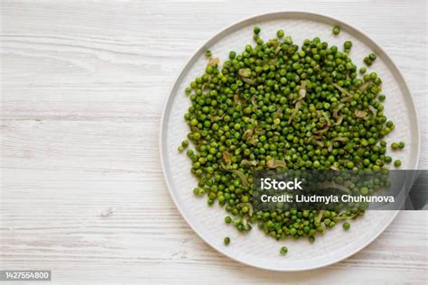 수제 Sauteed Green 완두콩을 흰색 나무 표면의 접시에 올려 놓고 상단 전망 위에서 평평한 누워 오버 헤드 공간을
