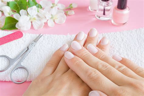 영 완벽 한 백색 수건에 여자의 손을 신랑 손톱 케어입니다 매니큐어 페디큐어 미용실 개념 파스텔 핑크 테이블에 사과 꽃의 아름