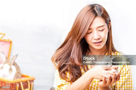 토끼를 나르는 여자 예쁜 젊은 여자 흰색 바탕에 귀여운 작은 토끼를 보유 하 고 있습니다 부활절에 토끼를 들고 있는 한 청 녀