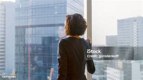 그녀의 사무실은 조심 스럽게 창 밖 보고 세련 된 드레스에 성공적인 사업가의 샷 개인용 컴퓨터와 큰 도시 보기 현대 비즈니스