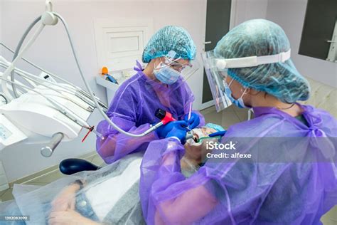 환자는 치과 의사와 그의 조수가 수술하는 수술용 의자에 누워 있습니다 수술에 대한 스톡 사진 및 기타 이미지 수술 치과교정