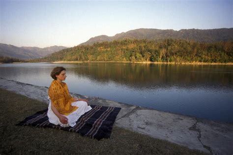 Premium Photo Woman Mediating At Lakeshore Against Sky