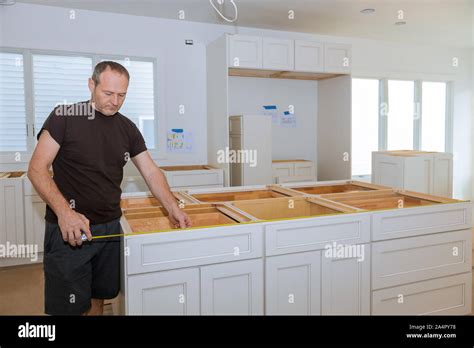 Man Using Tape Measure For Measuring Size In Modern Kitchen Material