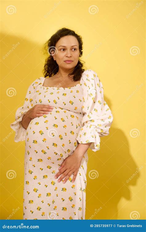 Beautiful Curly Haired Pregnant Woman In Summer Sundress Holding Her