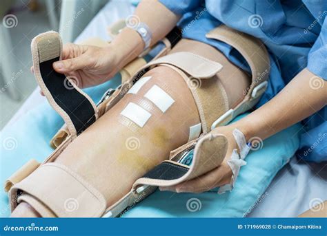 Hand Of Asian Woman Patient Sit On Bed In Hospital Try To Wear Knee