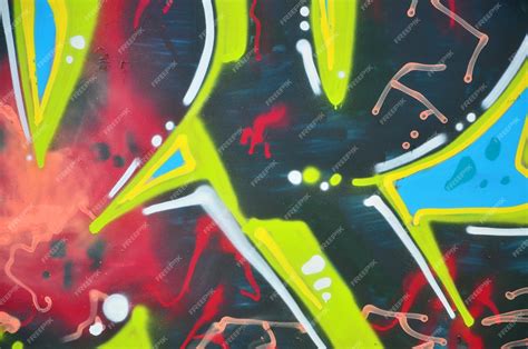 Старая стена окрашена в цветные граффити рисуя зеленые аэрозольные краски Премиум Фото