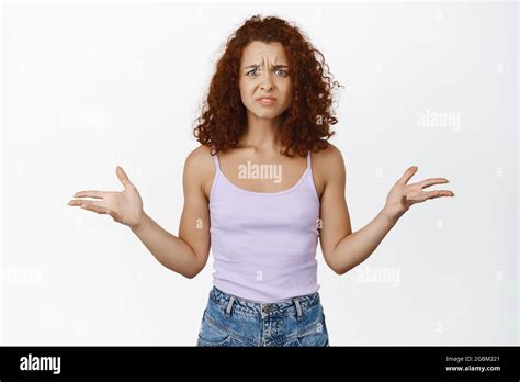 Whats Happening Frustrated Redhead Girl Shaking Hands And Shrugging