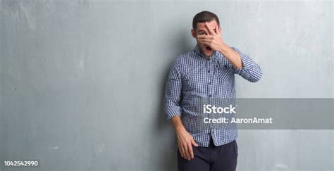 젊은 백인 남자 회색 그런 지 벽 충격 얼굴과 손으로 눈을 덮고 엿보기에 당황된 하는 표정으로 손가락을 통해 찾고 가리기에 대한 스톡 사진 및 기타 이미지 Istock