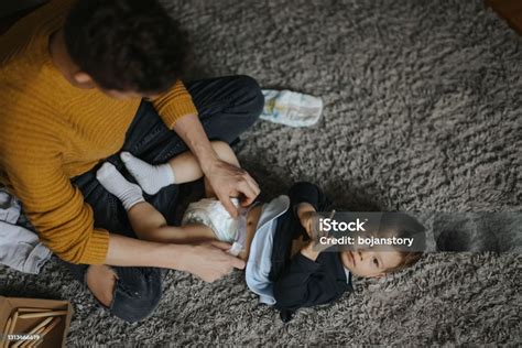 幼い父親が赤ちゃんの息子の世話をする オムツを替えるのストックフォトや画像を多数ご用意 オムツを替える 父親 おむつ Istock