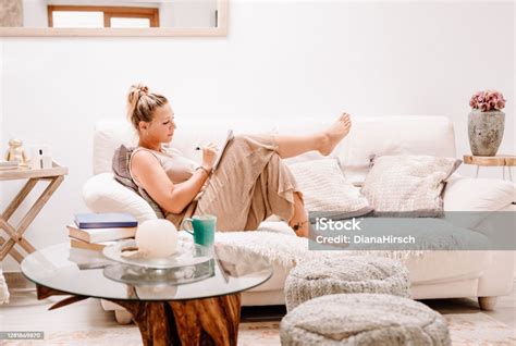 릴렉스 젊은 여자는 소파에 집에서 그녀의 할 일 목록을 작성 Comfort Food에 대한 스톡 사진 및 기타 이미지