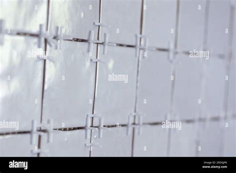 A Tile Wall Under Construction The Wall Is Being Tiled With Small Bumpy Rectangular Ceramic