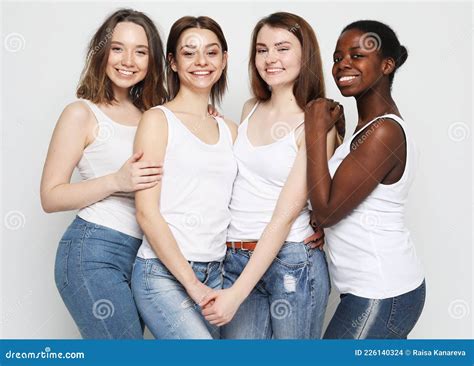 Grupo De Cuatro J Venes Amigas De Diferentes Nacionalidades Sobre Fondo Gris Foto De Archivo