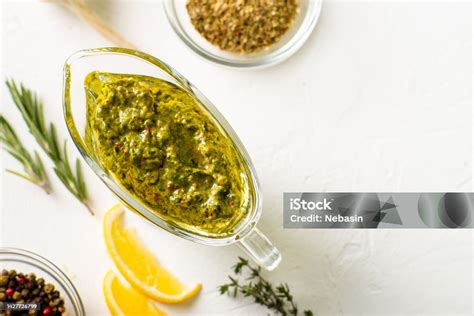 치미추리 소스에 그레이비 그릇에 흰색 배경 근처에는 다양한 향신료가 있습니다 올리브 오일 오레가노 파슬리로 만든 아르헨티나 채식 소스 텍스트에 대 한 배치 0명에 대한 스톡