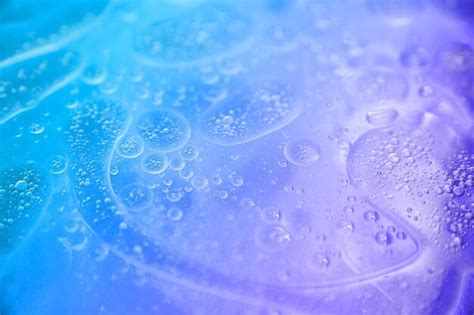 Fundo abstrato azul e roxo formado por gotas de óleo na água Foto Premium