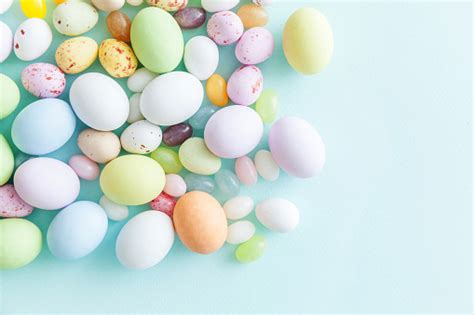 행복 한 부활절 개념입니다 부활절 사탕 초콜릿 계란과 트 렌 디 한 파스텔 블루 배경에 고립 젤리 빈 과자 간단한 미니 멀리즘