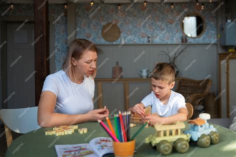 Madre Jugando Con Su Hijo Autista Usando Juguetes Foto Gratis