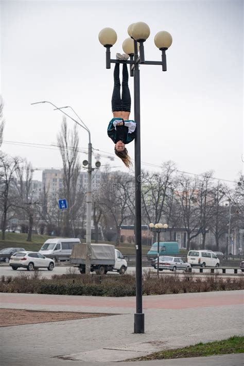 Girl Hanging By Feet Upside Down In The Street And Reading Book Concept Of Education And Self